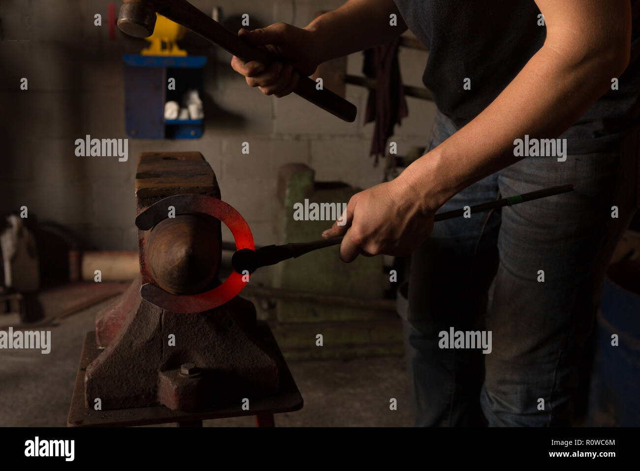 Female metalsmith molding horseshoe in factory Stock Photo - Alamy