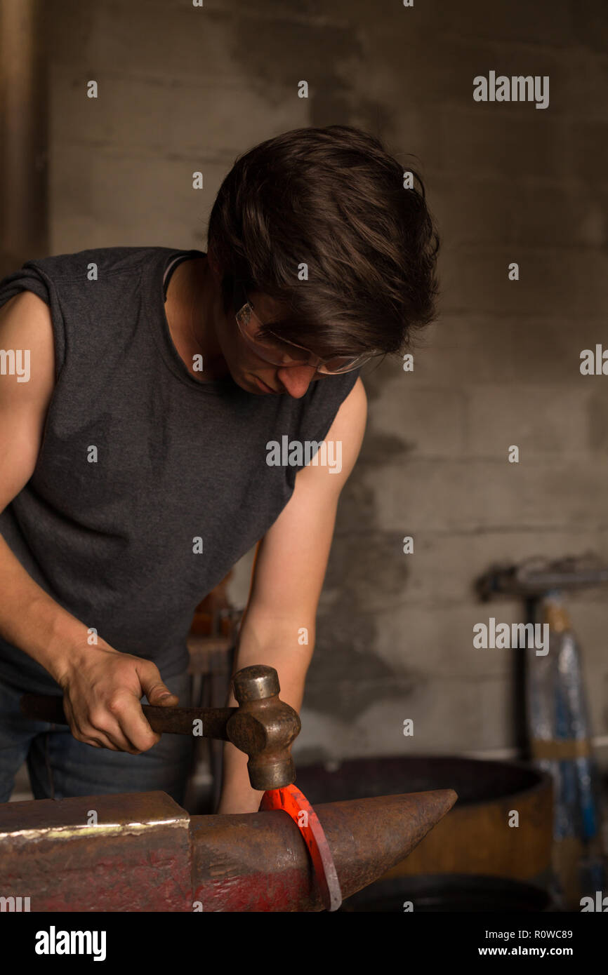 Female metalsmith molding horseshoe in factory Stock Photo - Alamy