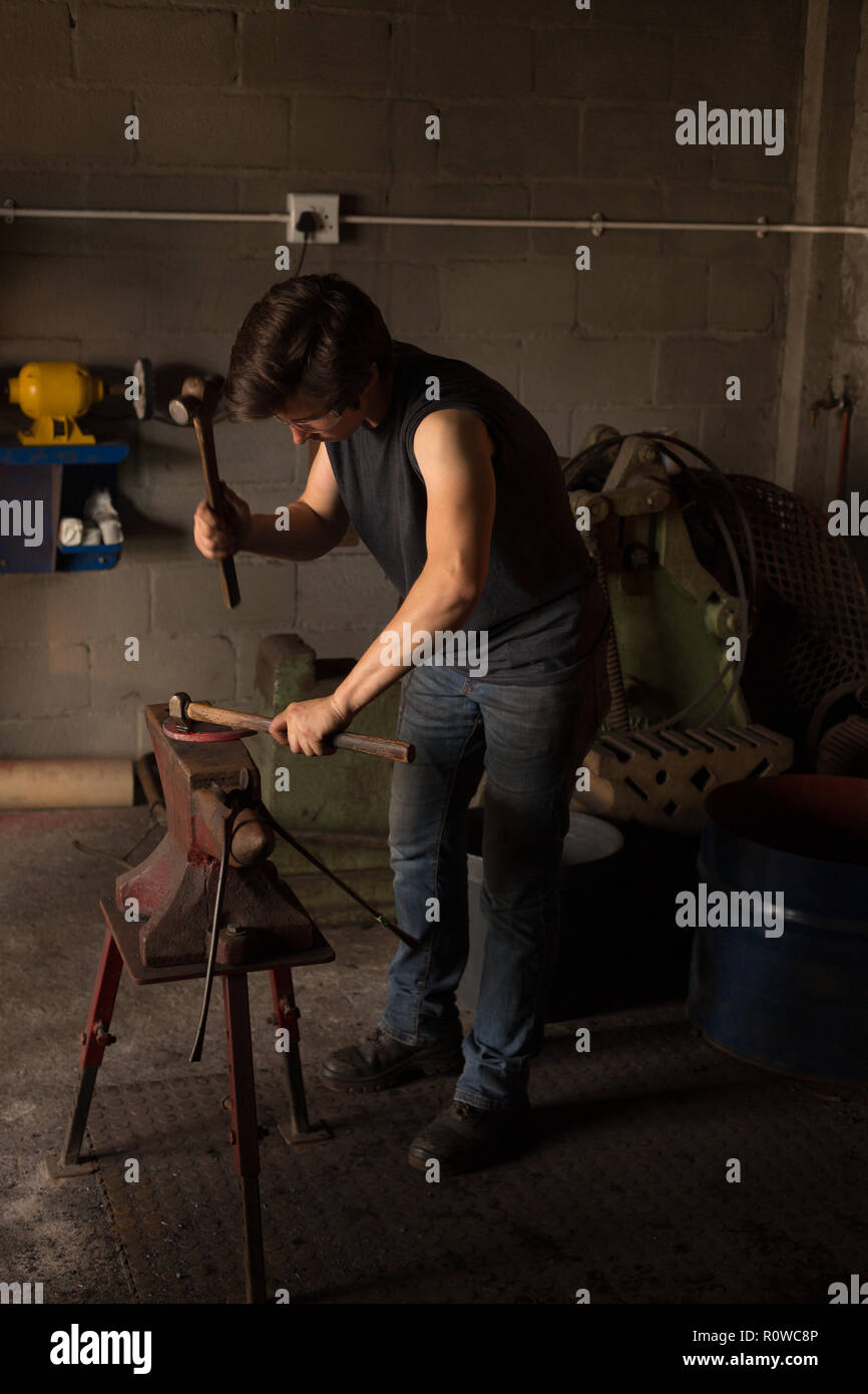 Female metalsmith molding horseshoe in factory Stock Photo - Alamy