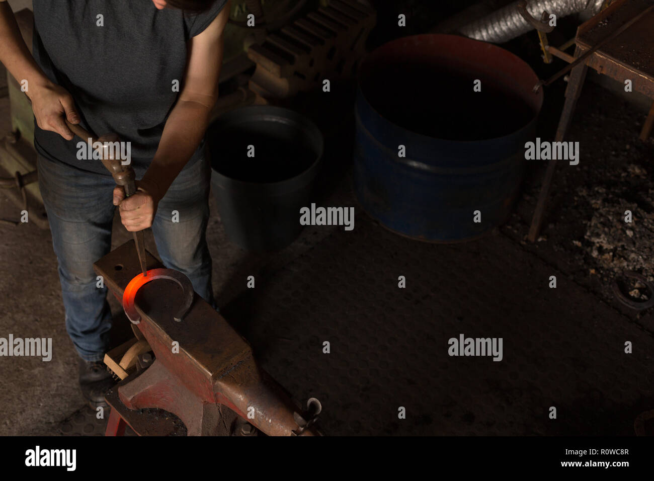 Female metalsmith molding horseshoe in factory Stock Photo - Alamy