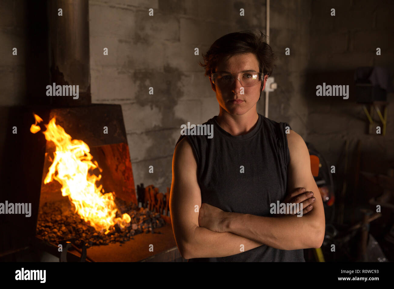 Female metalsmith standing with arms crossed in factory Stock Photo - Alamy