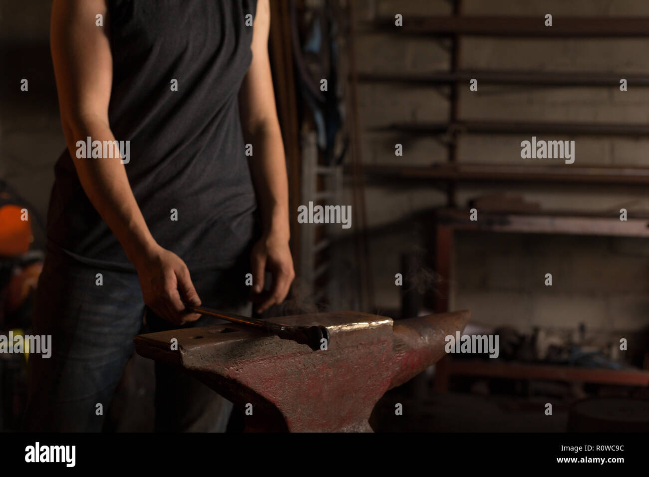 Female metalsmith holding tool in factory Stock Photo - Alamy