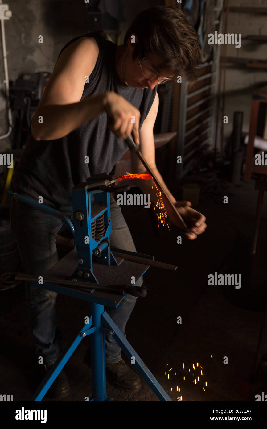 Female metalsmith shaping horseshoe in factory Stock Photo - Alamy
