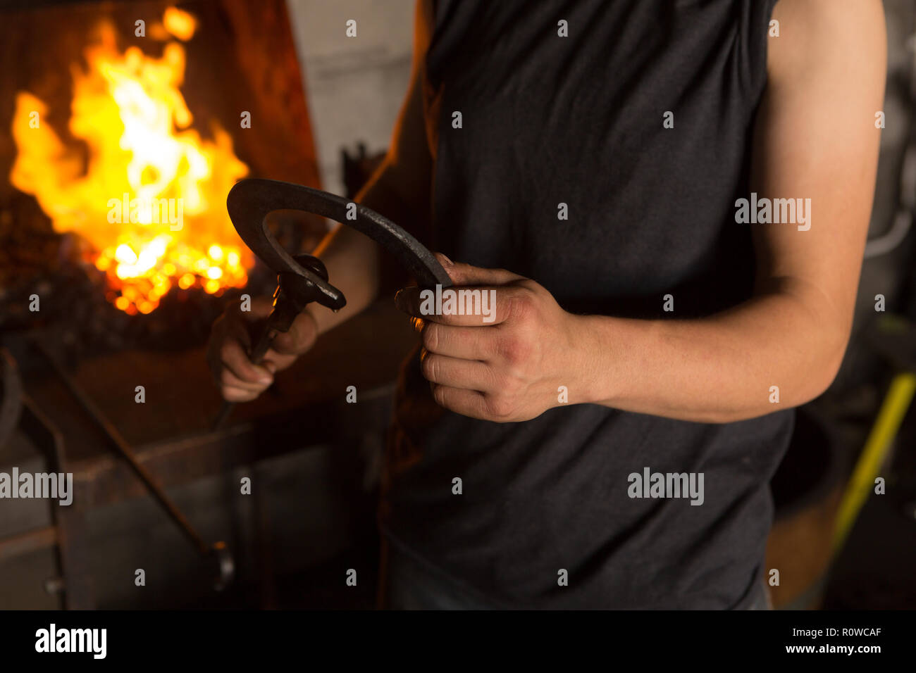 Female metalsmith molding horseshoe in factory Stock Photo - Alamy