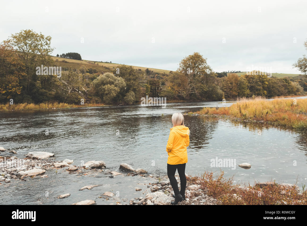 Woman standing near river Stock Photo - Alamy