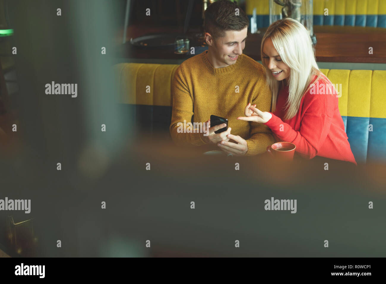 Blonde happy boy on smartphone screen against technological background ...