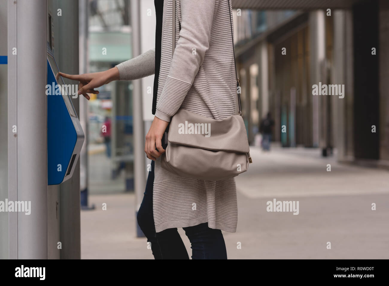 Woman using ticket vending machine at railway station Stock Photo - Alamy