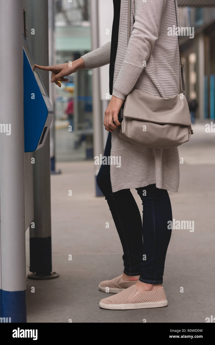 Woman using ticket vending machine at railway station Stock Photo - Alamy