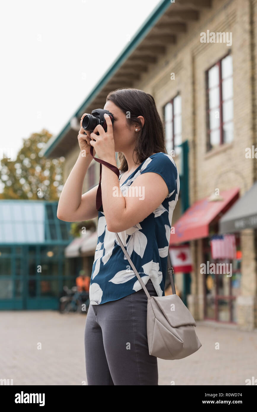 Woman clicking photos with camera in the city Stock Photo - Alamy