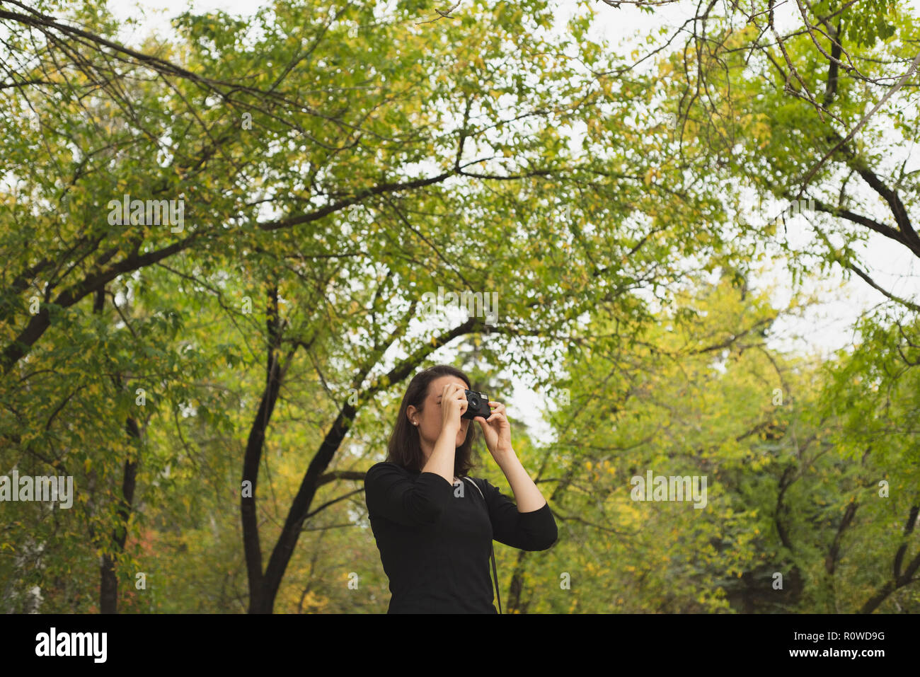 Woman clicking photos with camera Stock Photo - Alamy