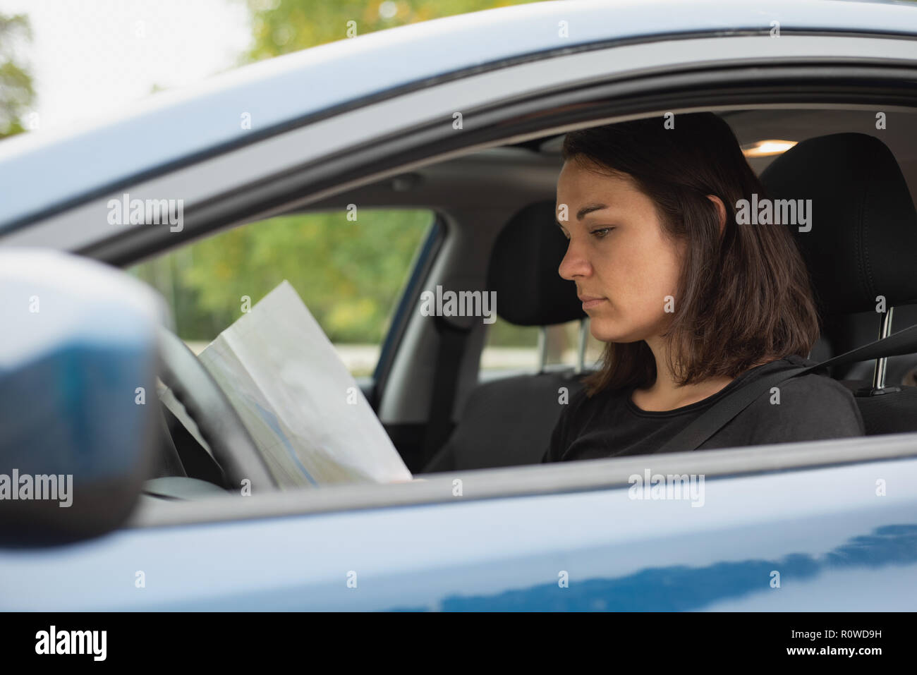 Woman looking at map in the car Stock Photo - Alamy