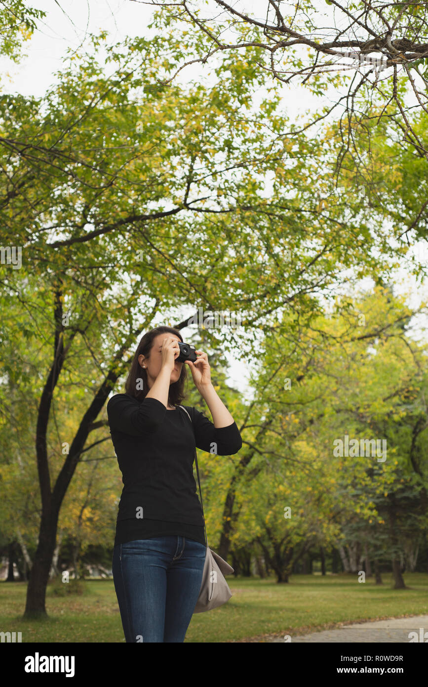 Woman clicking photos with camera Stock Photo - Alamy