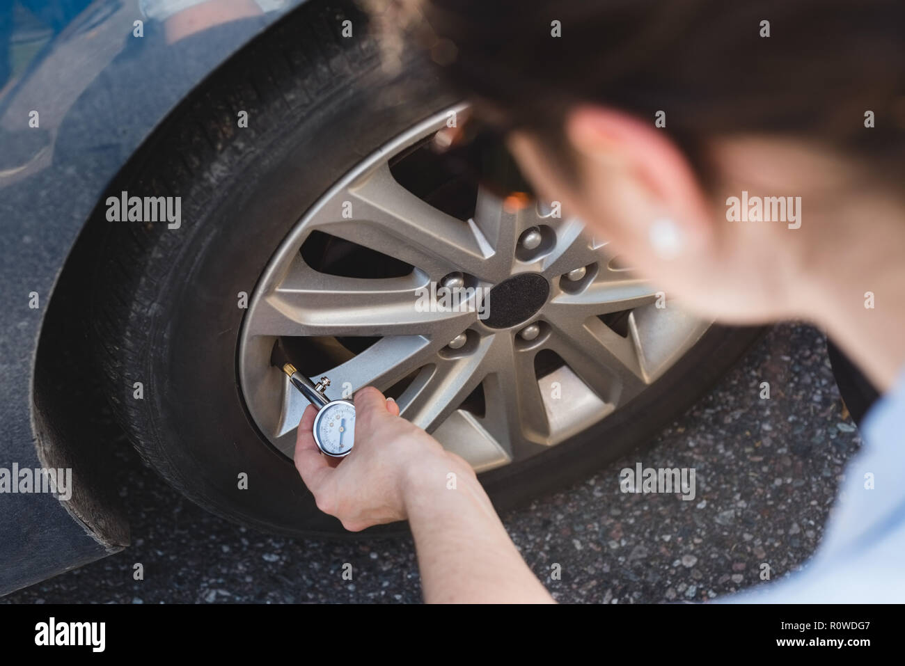 Woman checking a tyre on a road Stock Photo - Alamy