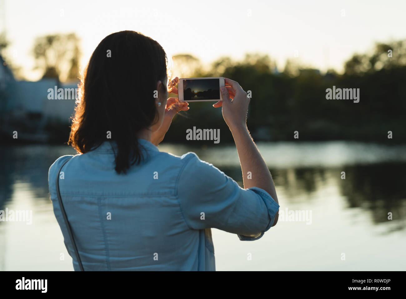 Woman clicking photos with mobile phone Stock Photo - Alamy