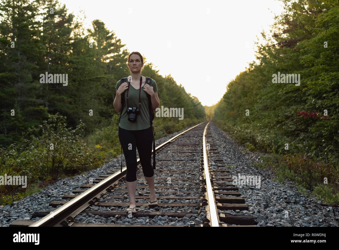 Woman walking on a railway track Stock Photo - Alamy