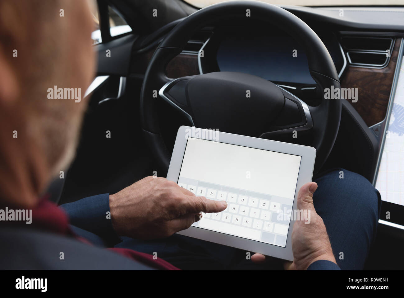 Businessman using digital tablet in a car Stock Photo - Alamy