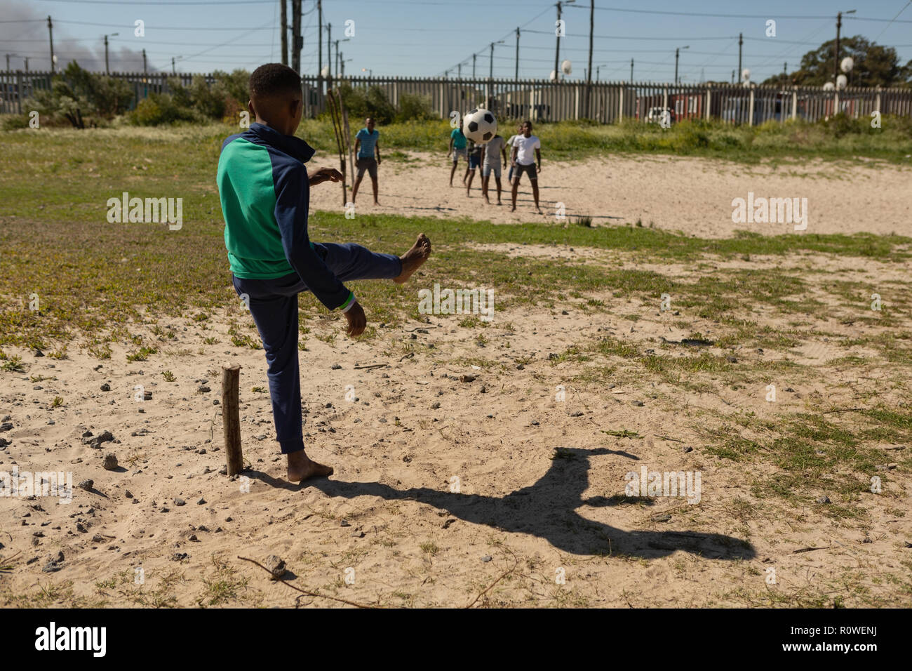 Kids playing football in the ground Stock Photo - Alamy