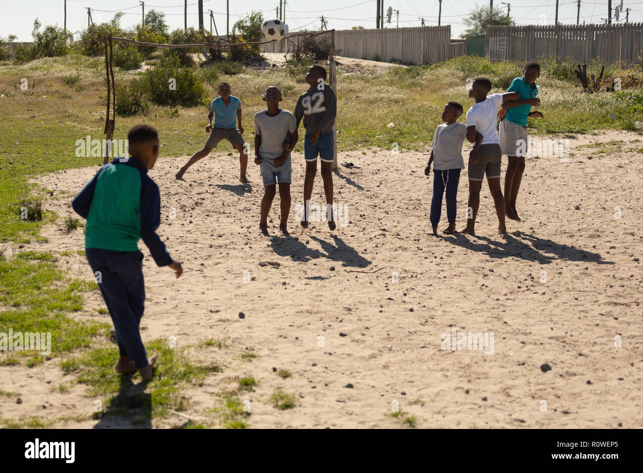 Kids playing football in the ground Stock Photo - Alamy