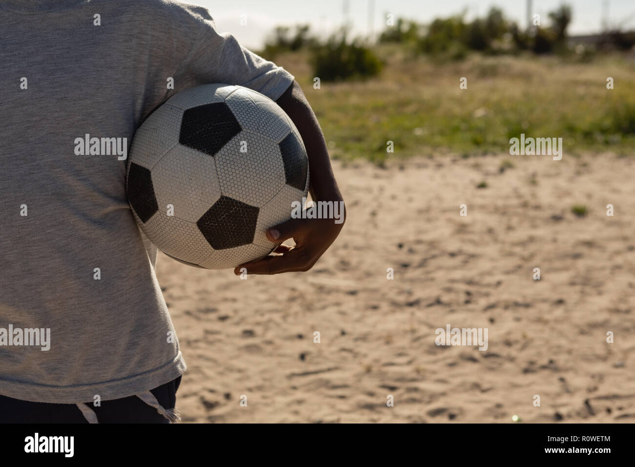 Boy holding football in the ground Stock Photo - Alamy