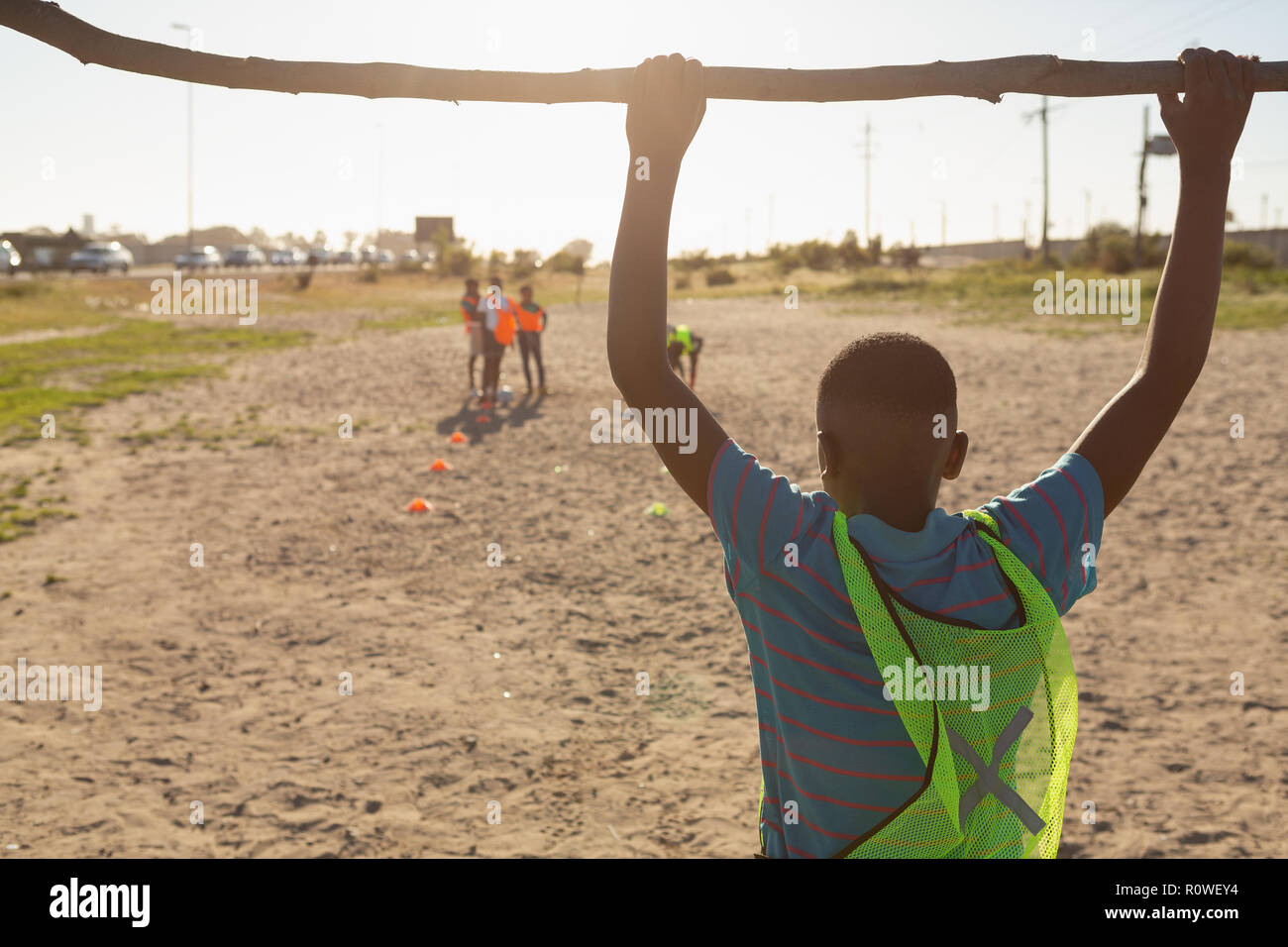 Boy hanging on goal post in the ground Stock Photo - Alamy