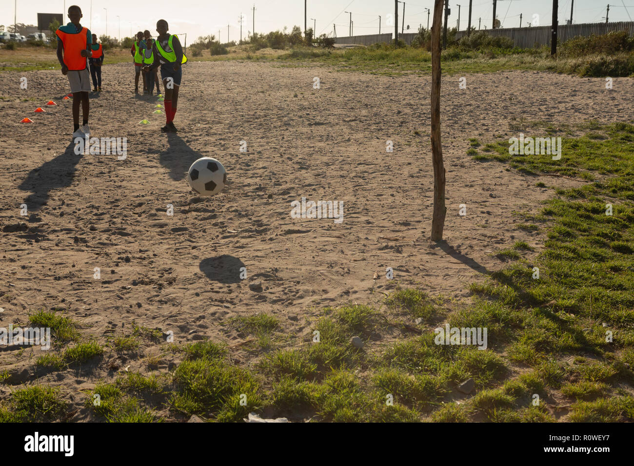 Kids playing football in the ground Stock Photo - Alamy