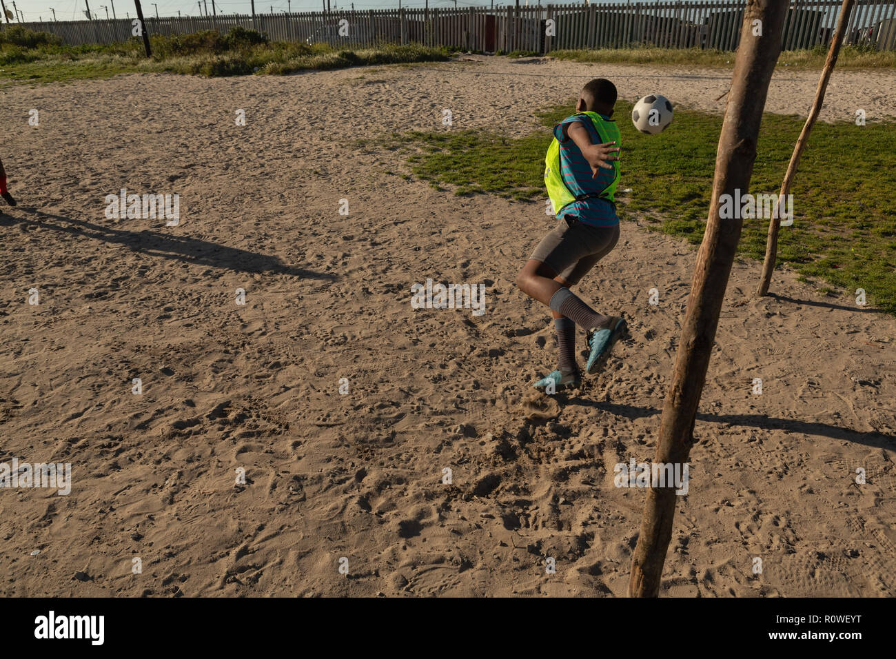 Boy playing football in the ground Stock Photo - Alamy