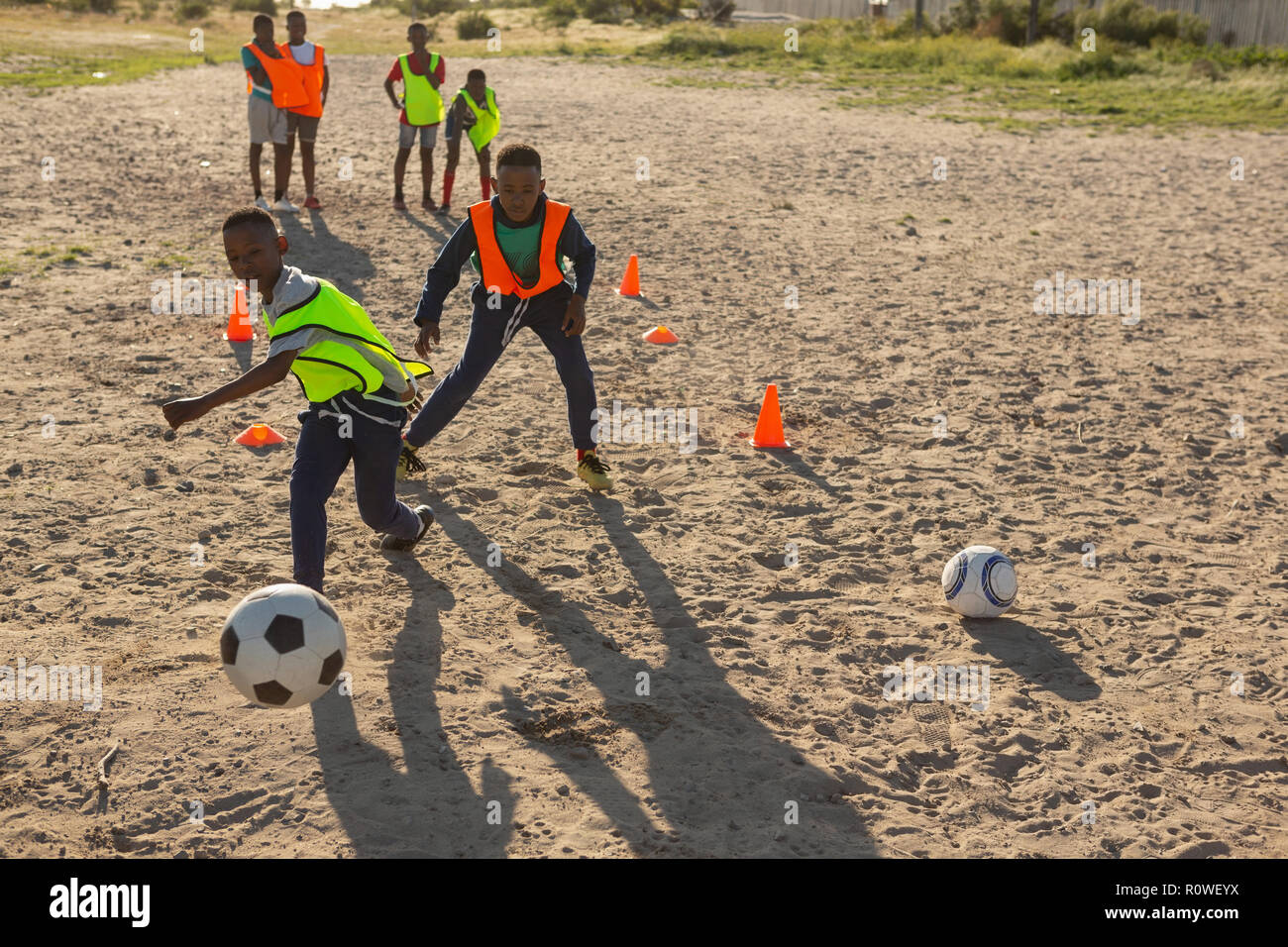 Kids playing football in the ground Stock Photo - Alamy
