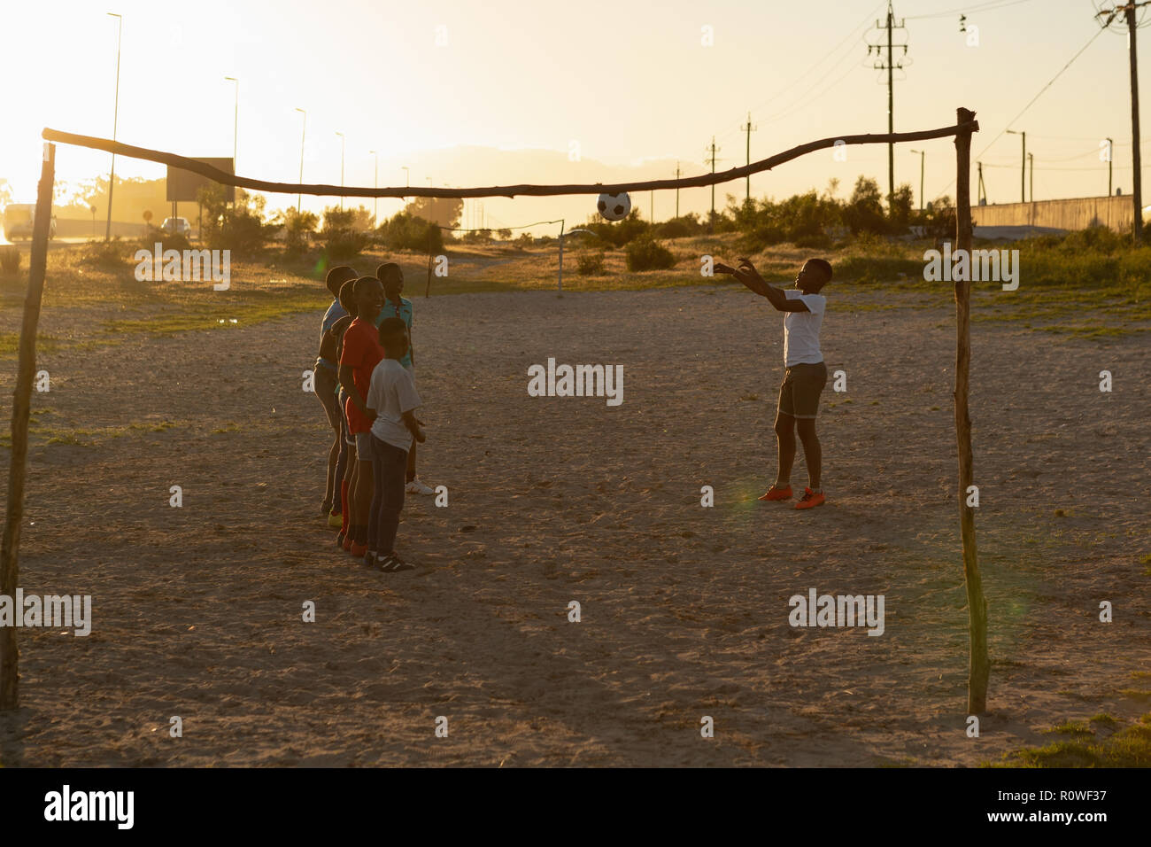Kids playing with football in the ground Stock Photo - Alamy