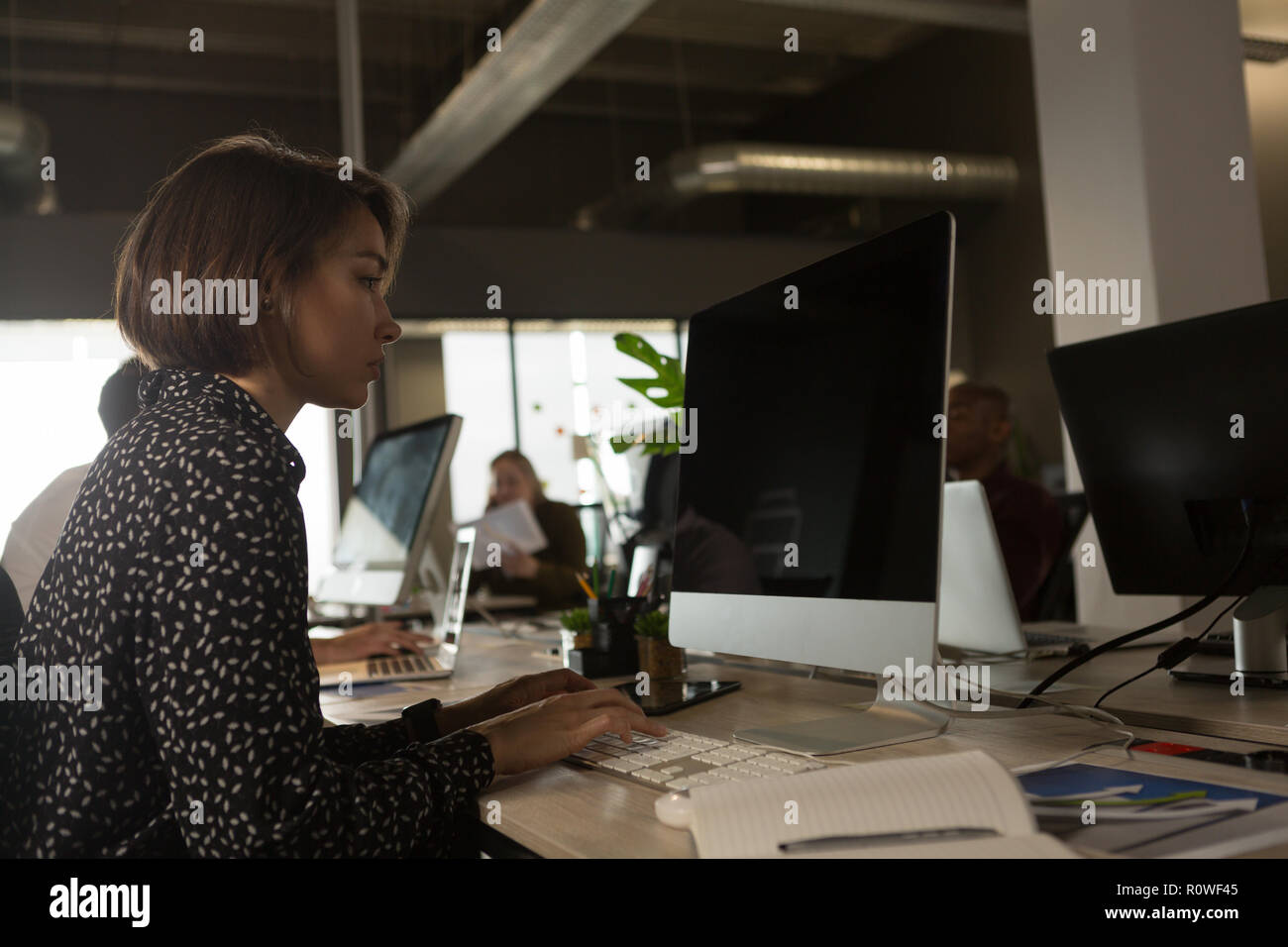 Executive working at desktop in office Stock Photo - Alamy
