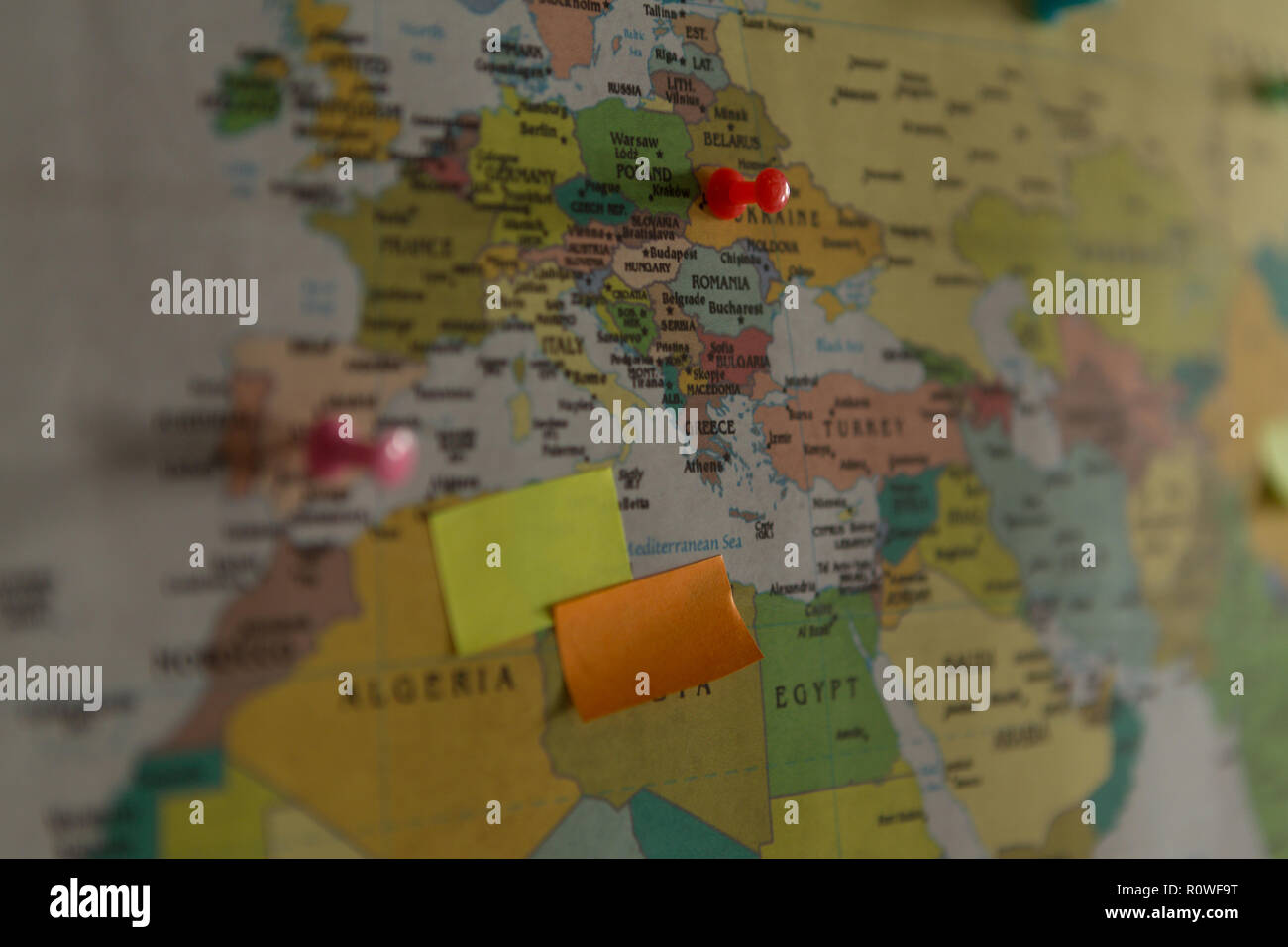 Sticky notes and board pin attached on world map Stock Photo - Alamy