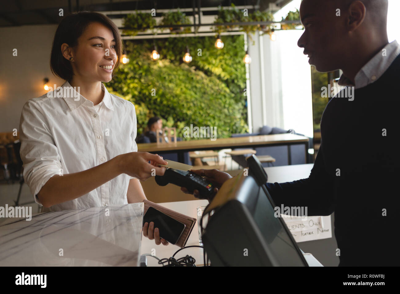 Black man transaction mobile phone hi-res stock photography and images ...