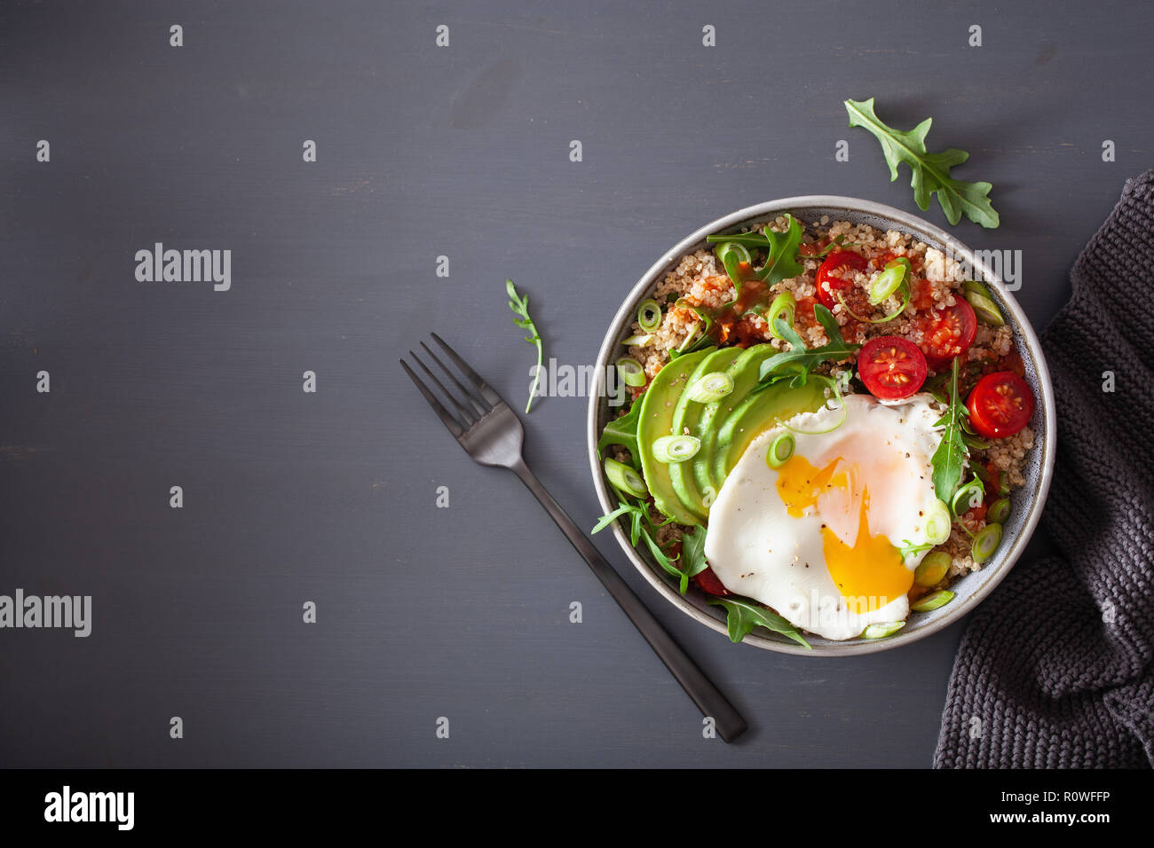 quinoa bowl with fried egg, avocado, tomato, rocket. Healthy vegetarian ...