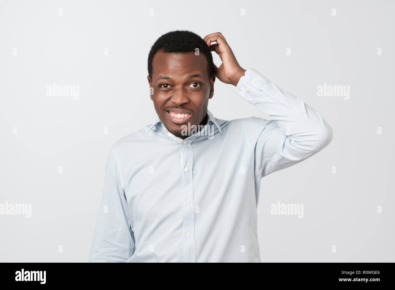 Confused African Man Scratching Head While Looking At Camera And