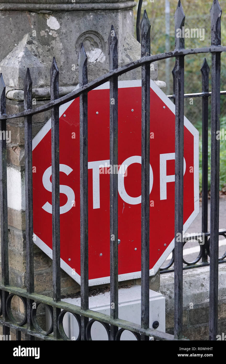 Stop sign with metal gate railing Stock Photo - Alamy