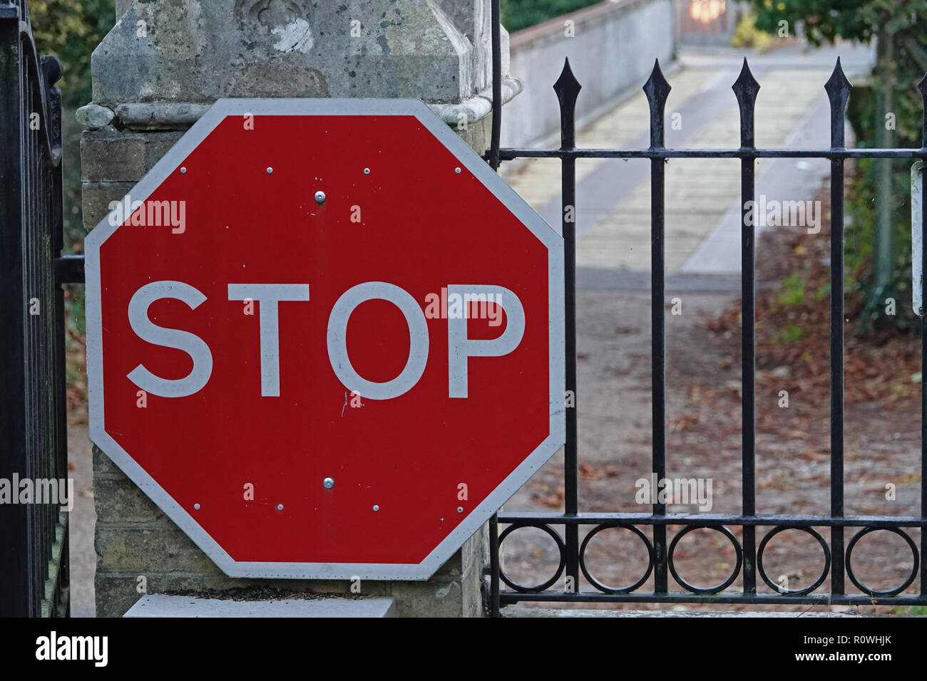 Stop sign with metal gate railing Stock Photo - Alamy