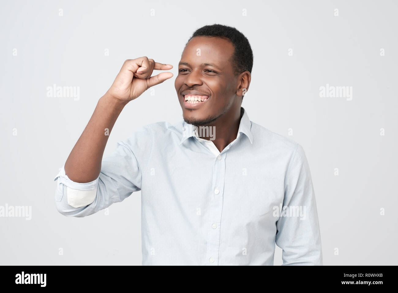 Young african man holding something small in his hands Stock Photo - Alamy