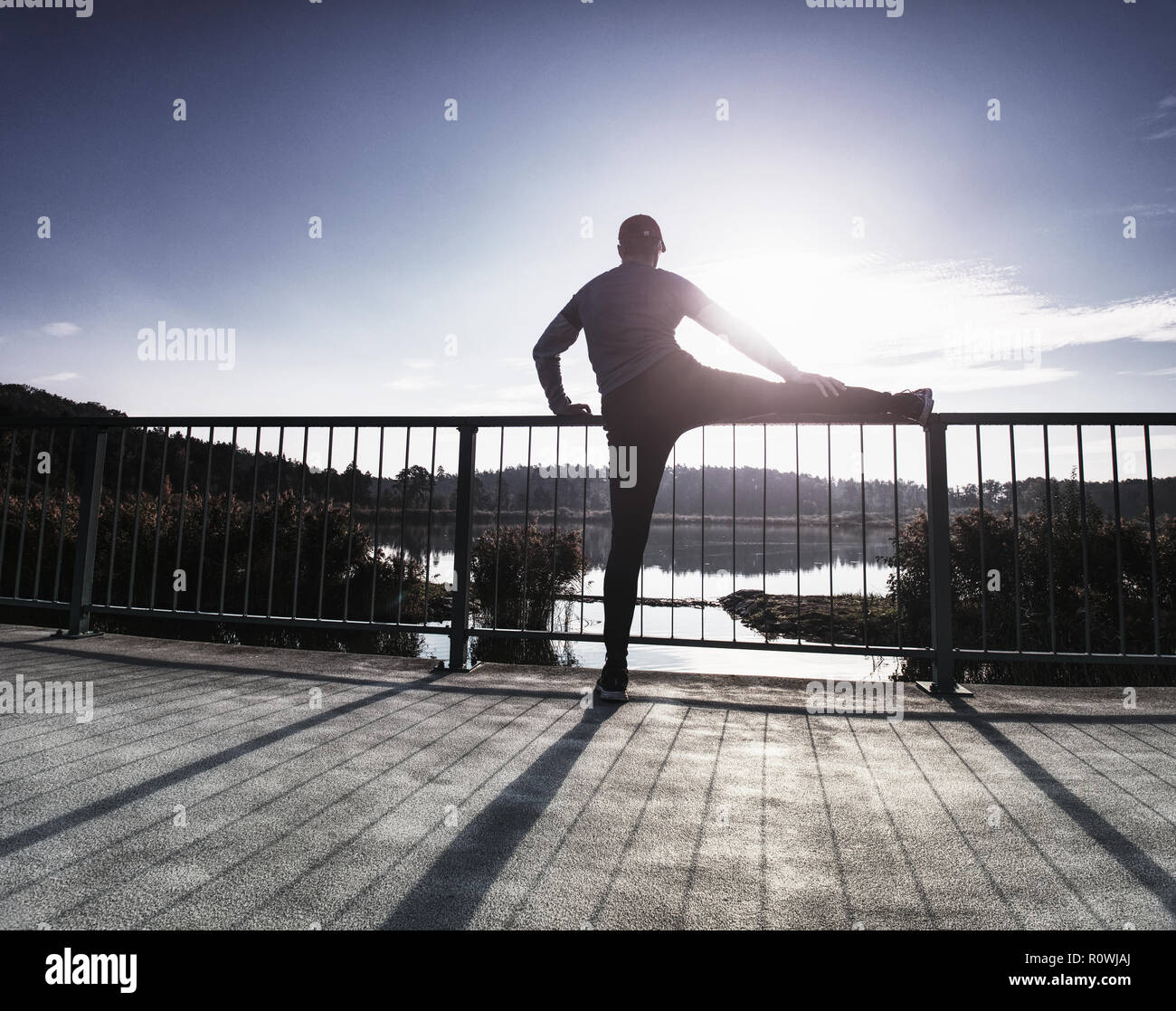 Workout runner. Man do stretching, taking a break from run outside in ...