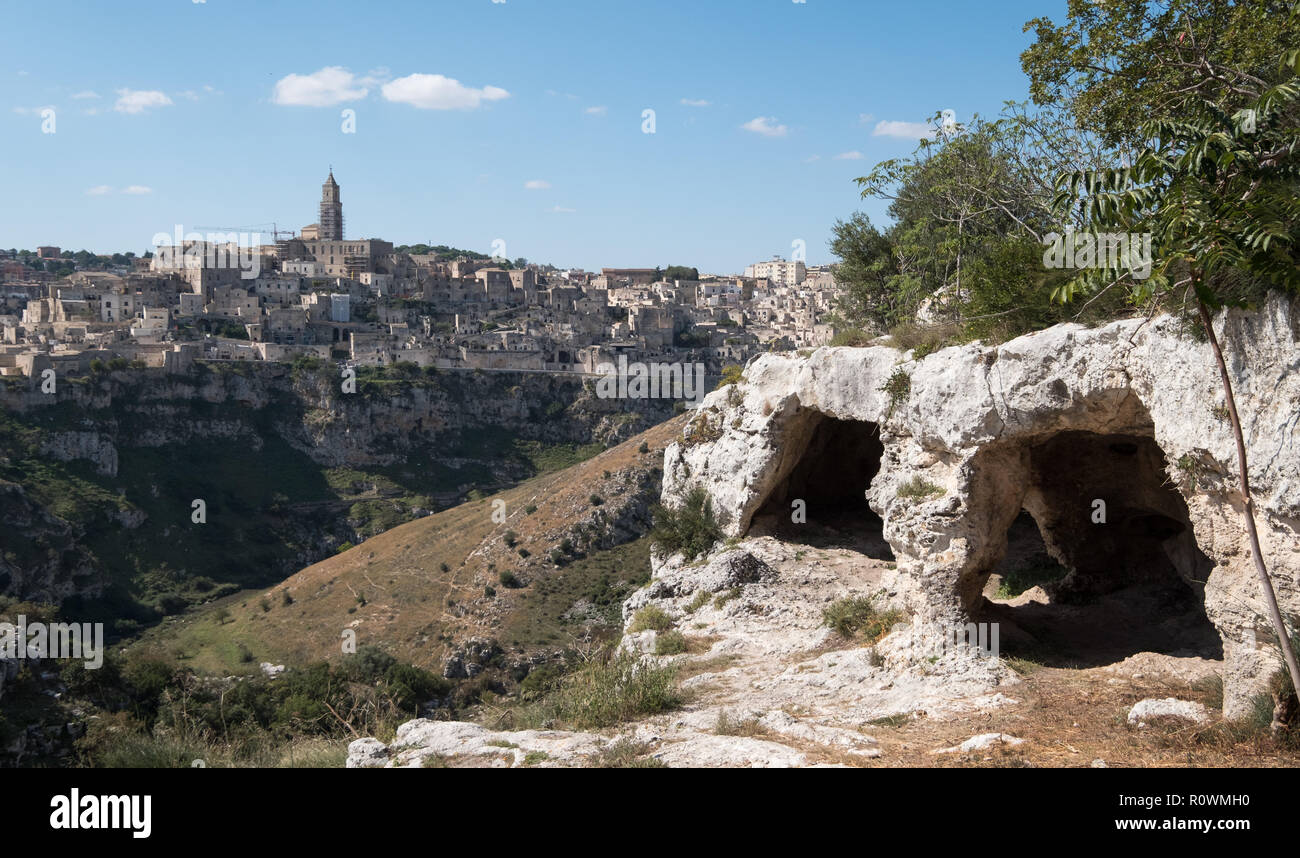 In the background, houses built into rock in the ravine in the historic ...