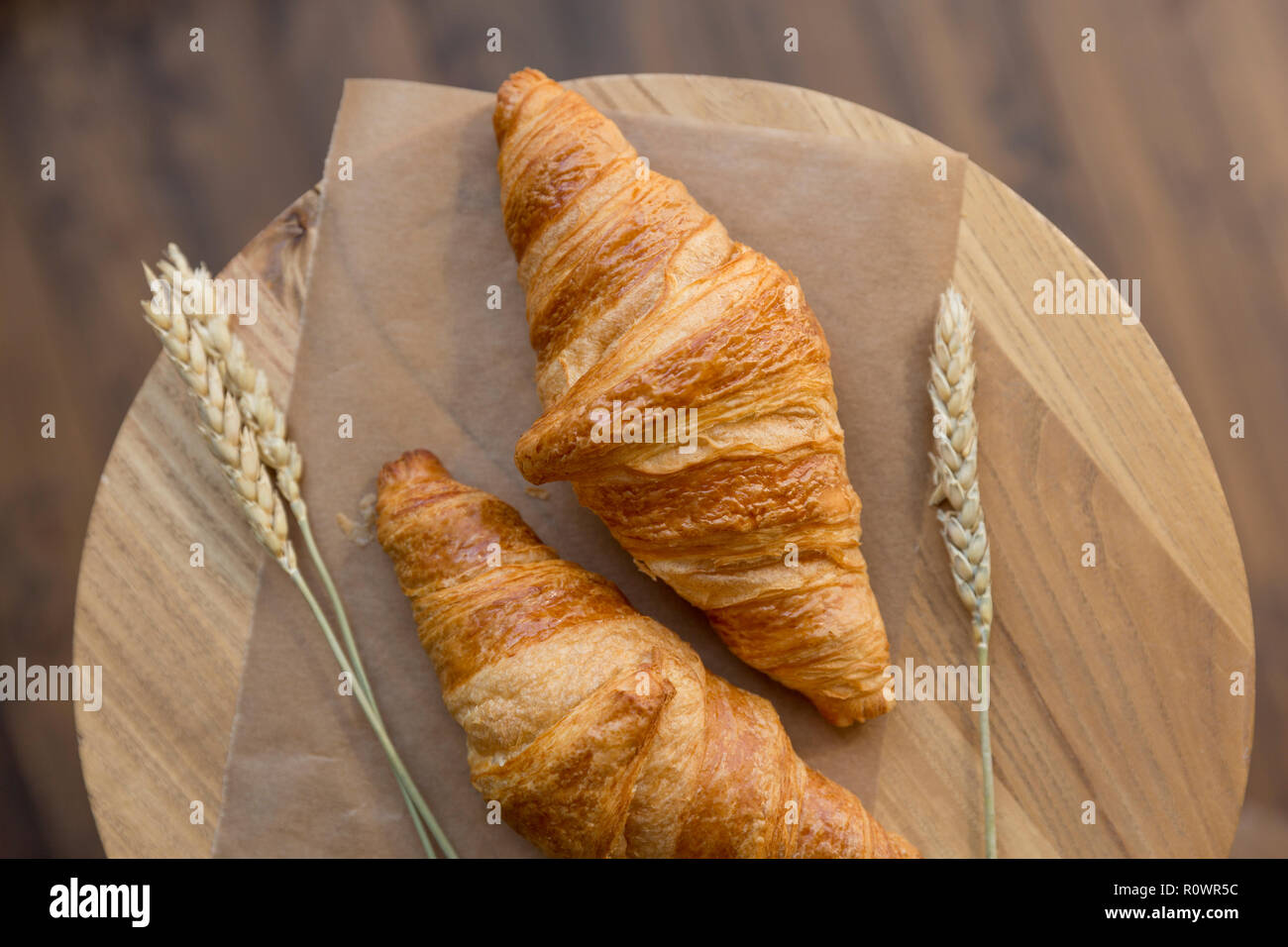 Breakfast. Croissants with wheat ears at baking paper on dark ...