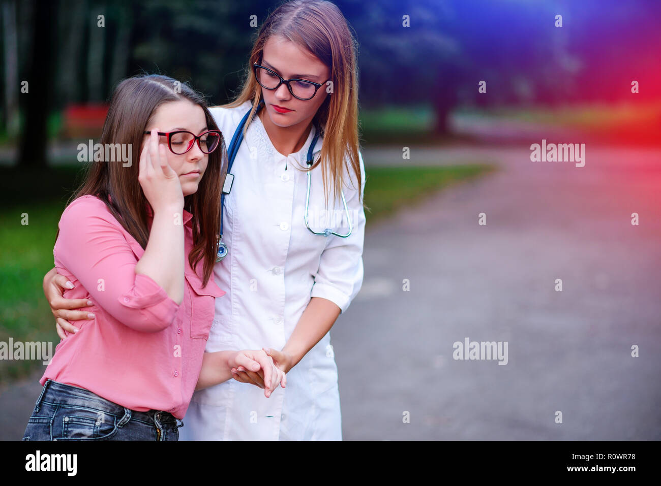 caring doctor or nurse taking young patient outdoors, the patient ...