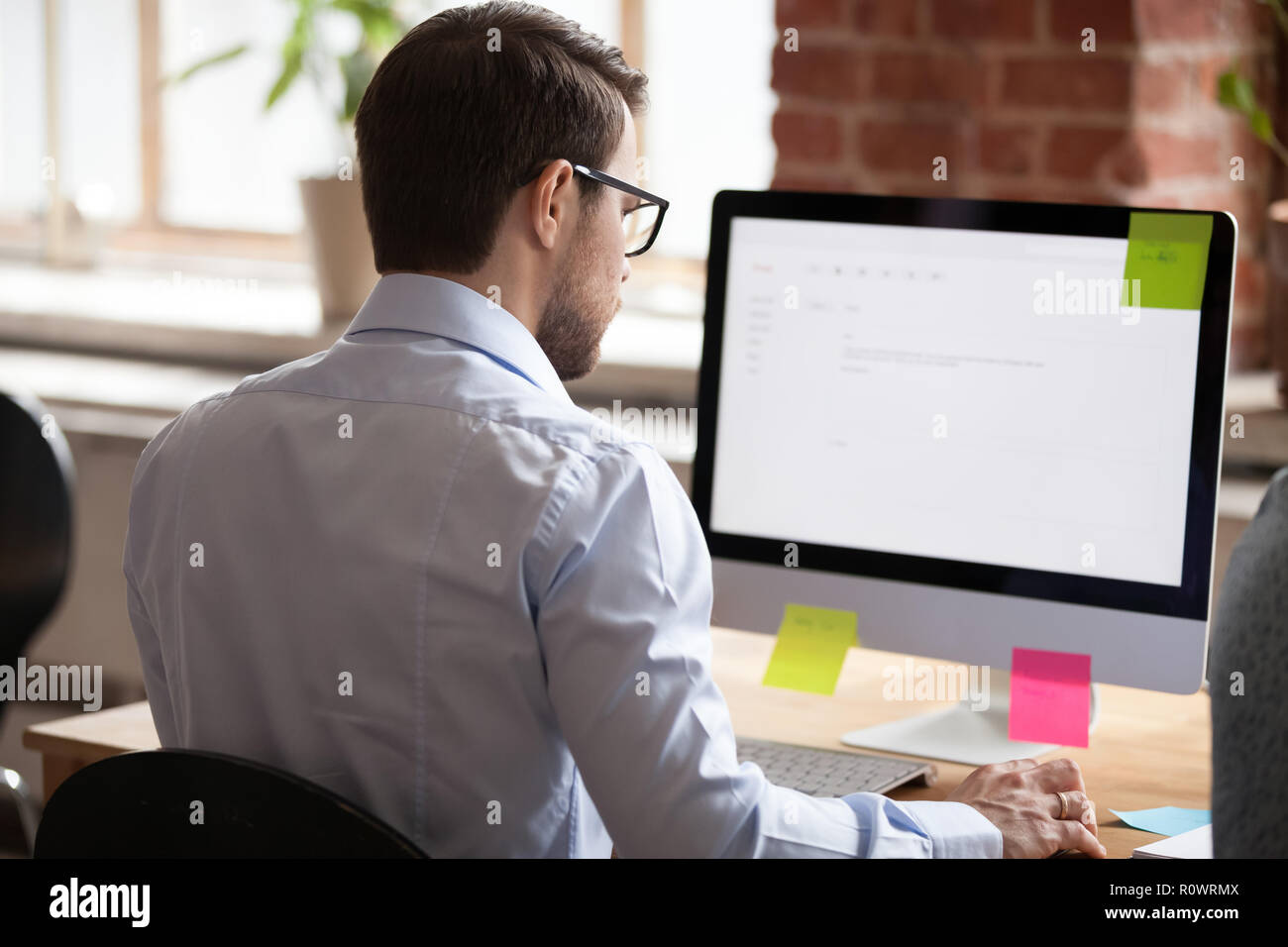 Serious male employee write business letter to client Stock Photo - Alamy