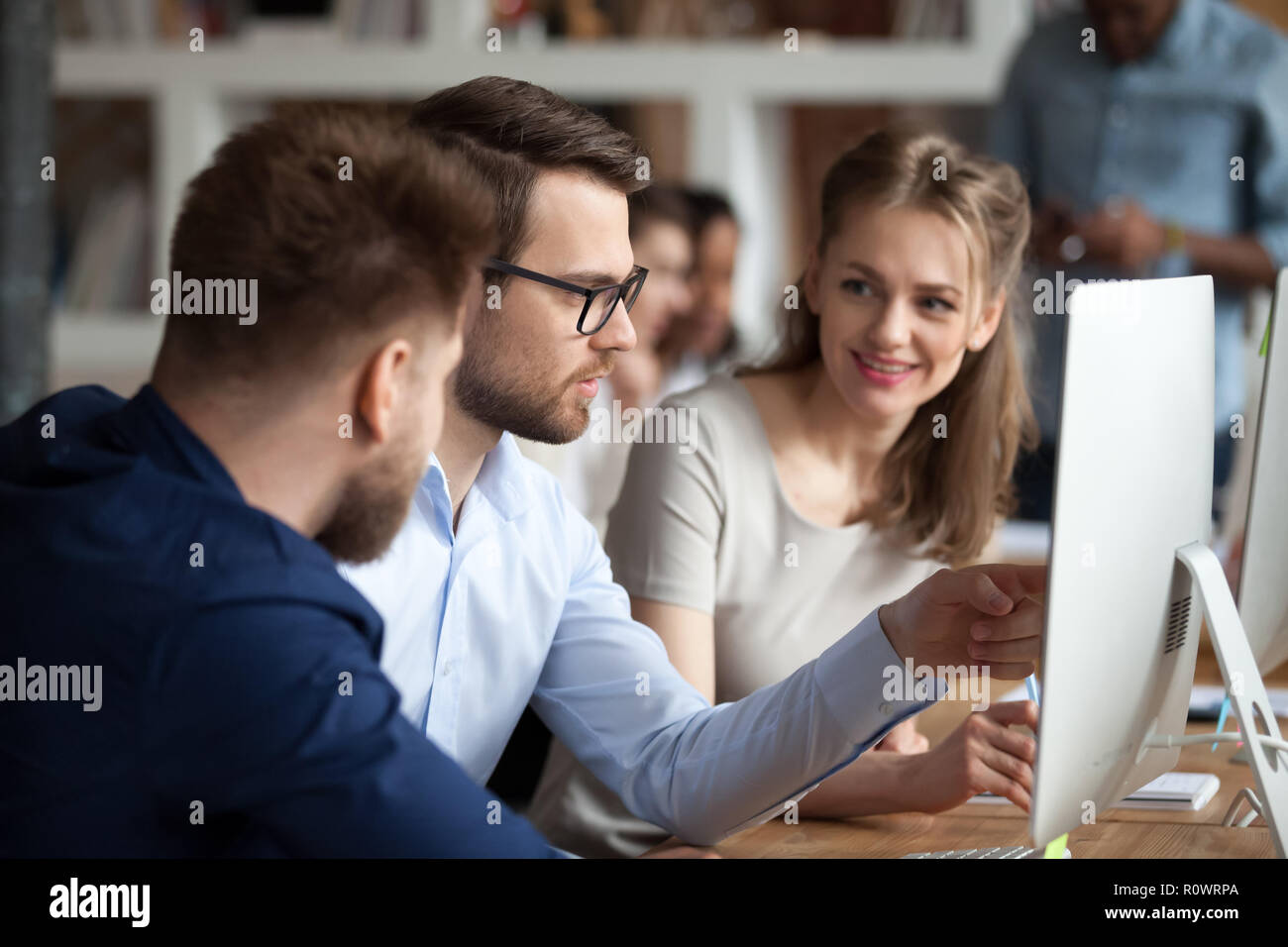 Diverse employees smile working together at pc Stock Photo - Alamy