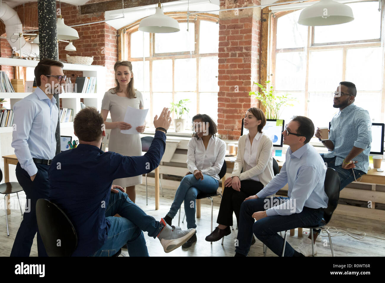 Male worker raise hand asking question at office teambuilding Stock ...