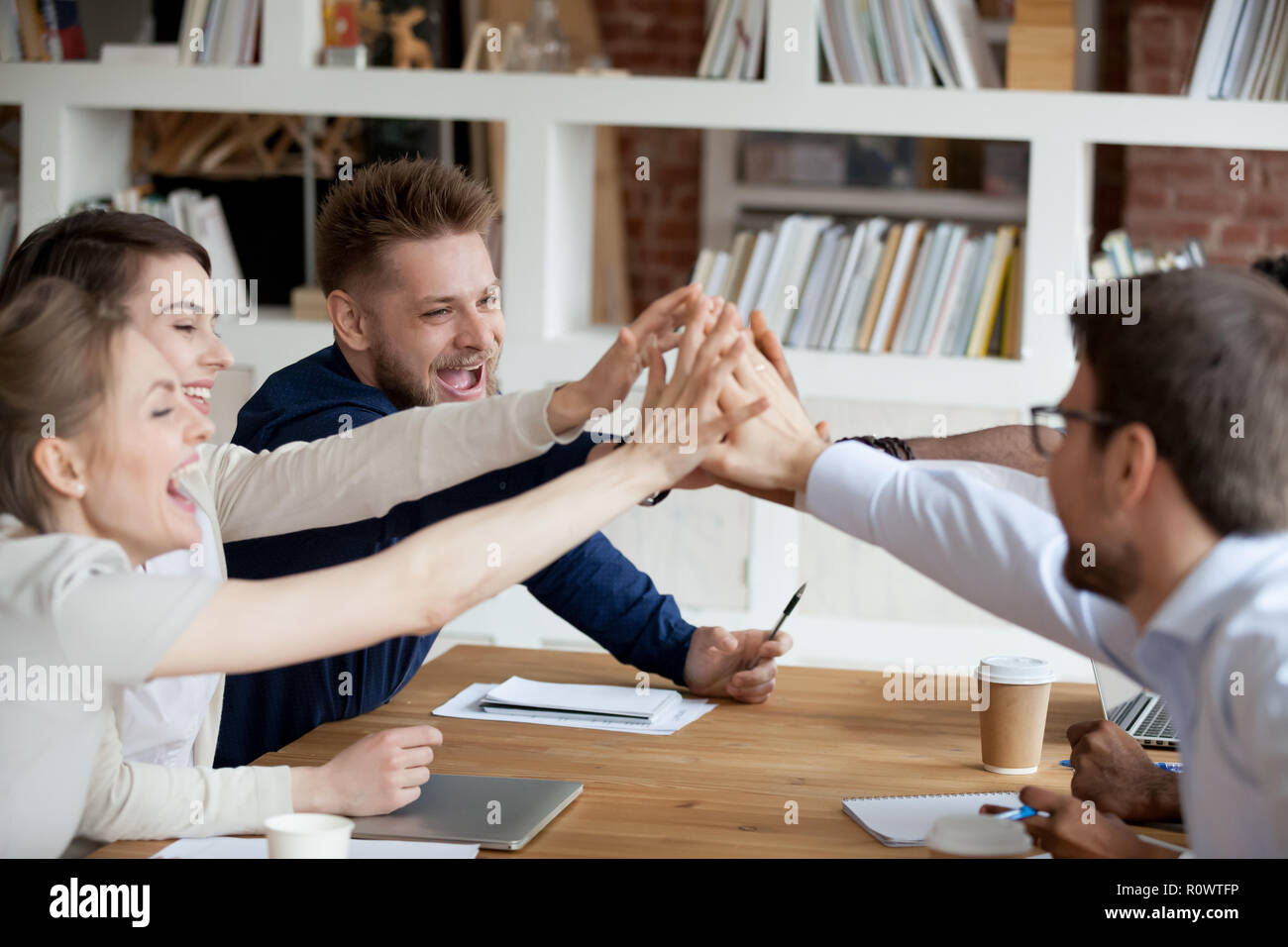 Excited employees give high five celebrating shared success Stock Photo ...