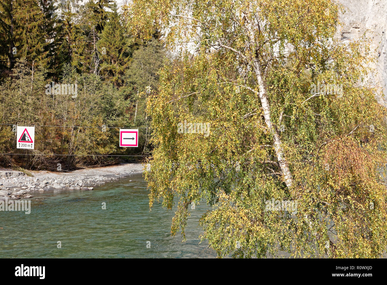 Signs "falling stones" and "keep right" above Rhine river in sunny ...