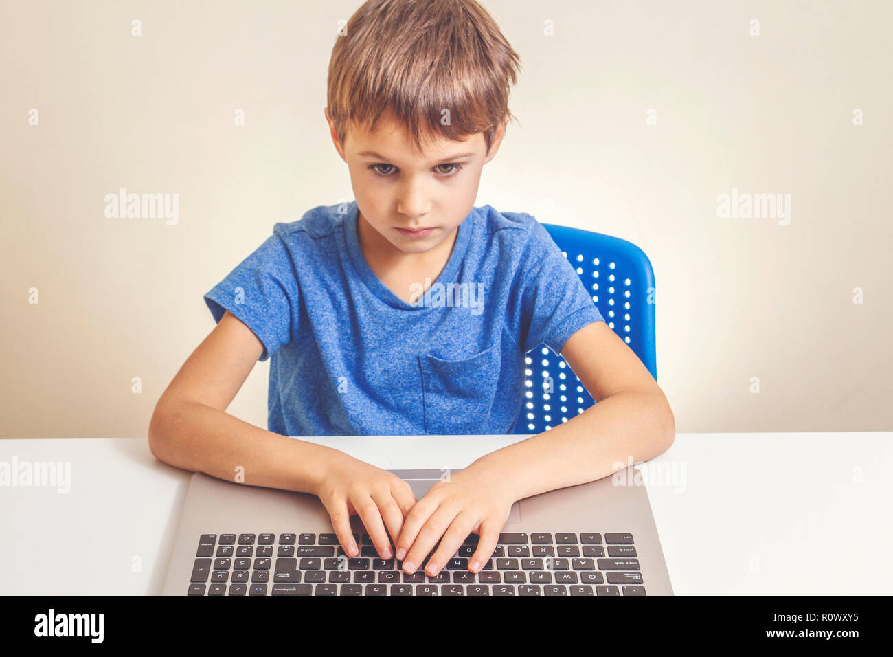 Concentrated boy typing on laptop computer Stock Photo - Alamy