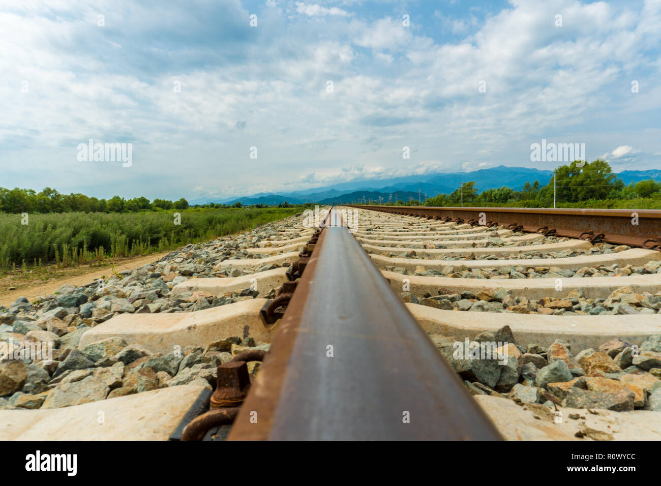 Railroad tracks leading to endless infinity. Meadow landscape and ...