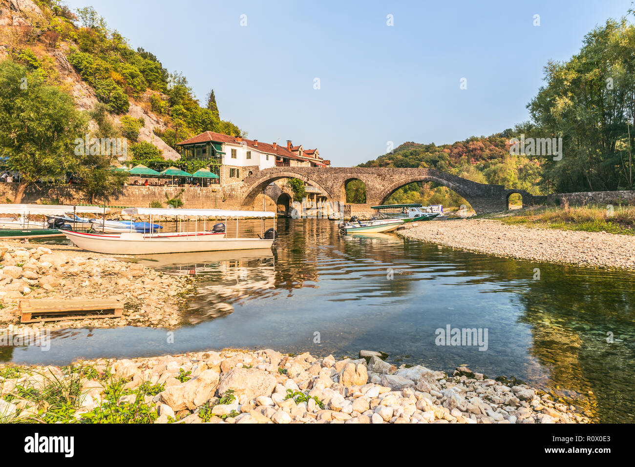 Old arched stone bridge across the river Crnojević, Montenegro. Boat ...