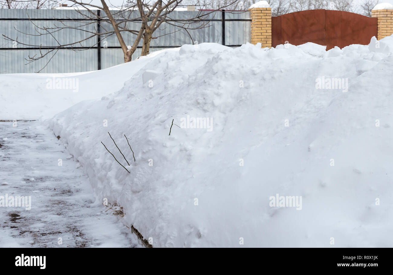 In a small courtyard cleared the path next to the large snowdrifts of ...