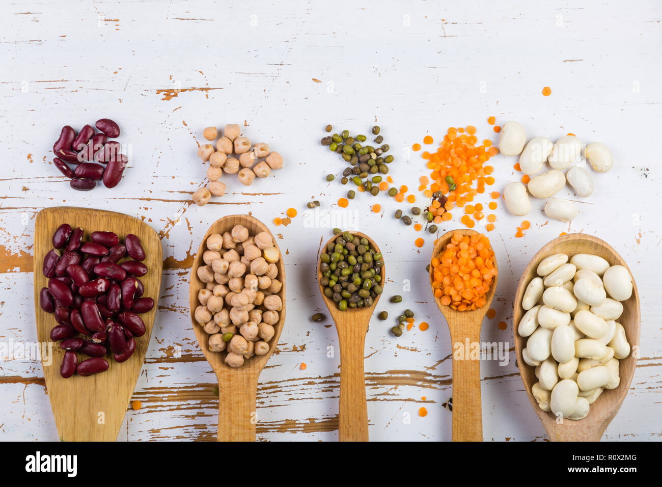Selection of colorful beans on white wood background Stock Photo - Alamy
